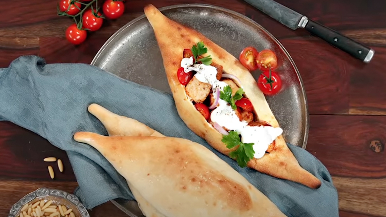 Samoon Bread With Cream Cheese, Harissa, Spicy Chicken, Tomatoes, and Herbs